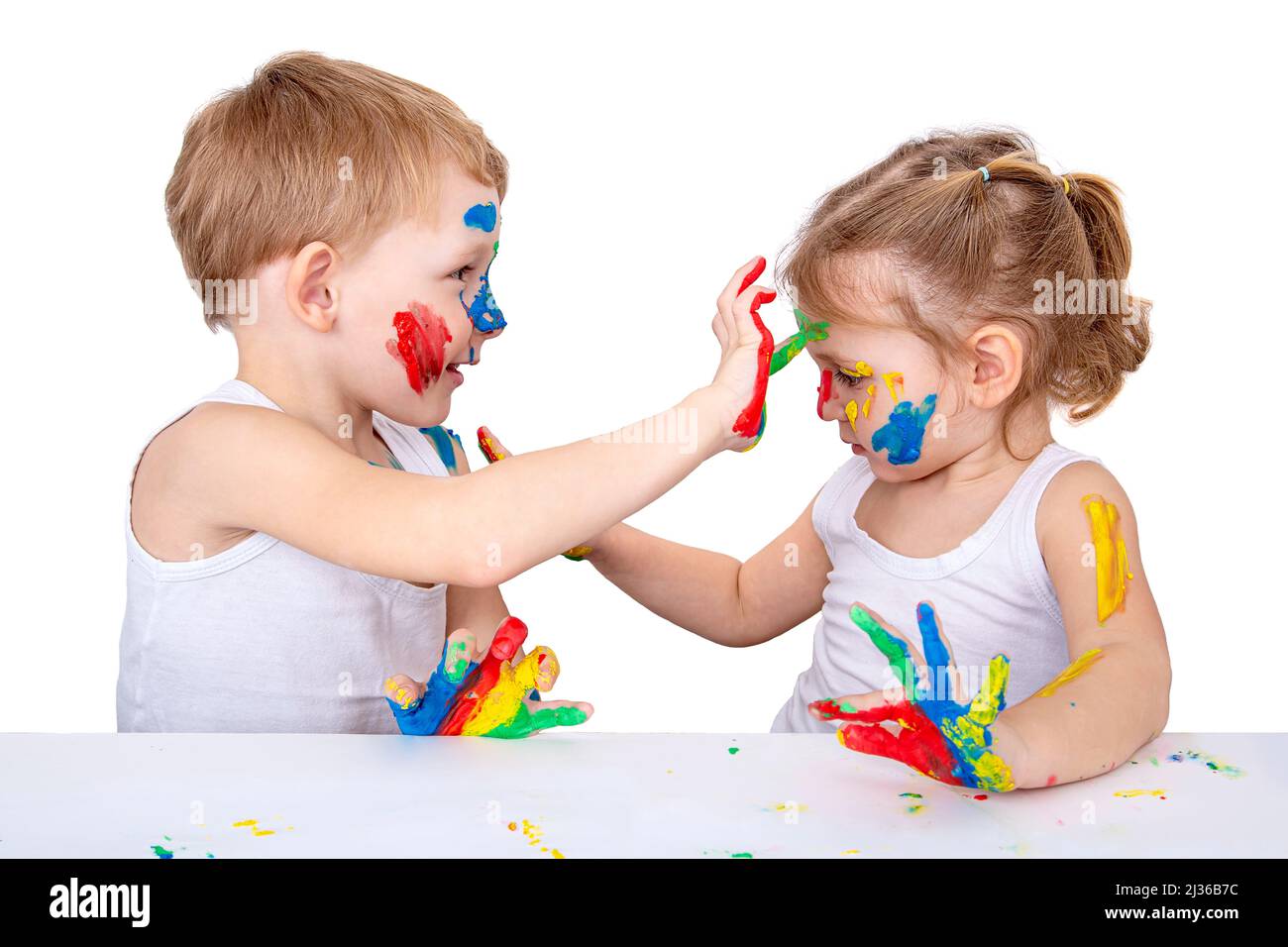 Small children draw on each other with finger paints on a white ...