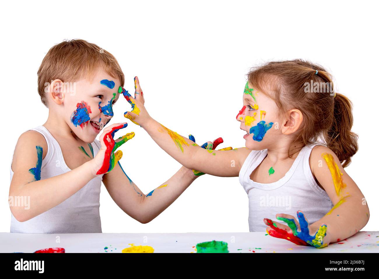 Small children draw on each other with finger paints on a white ...