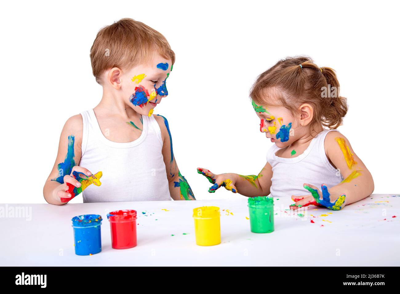 Small children draw on each other with finger paints on a white ...