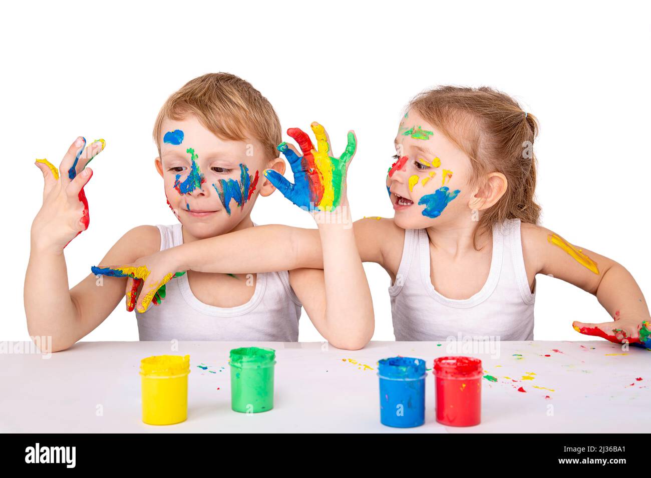 Small children draw on each other with finger paints on a white ...