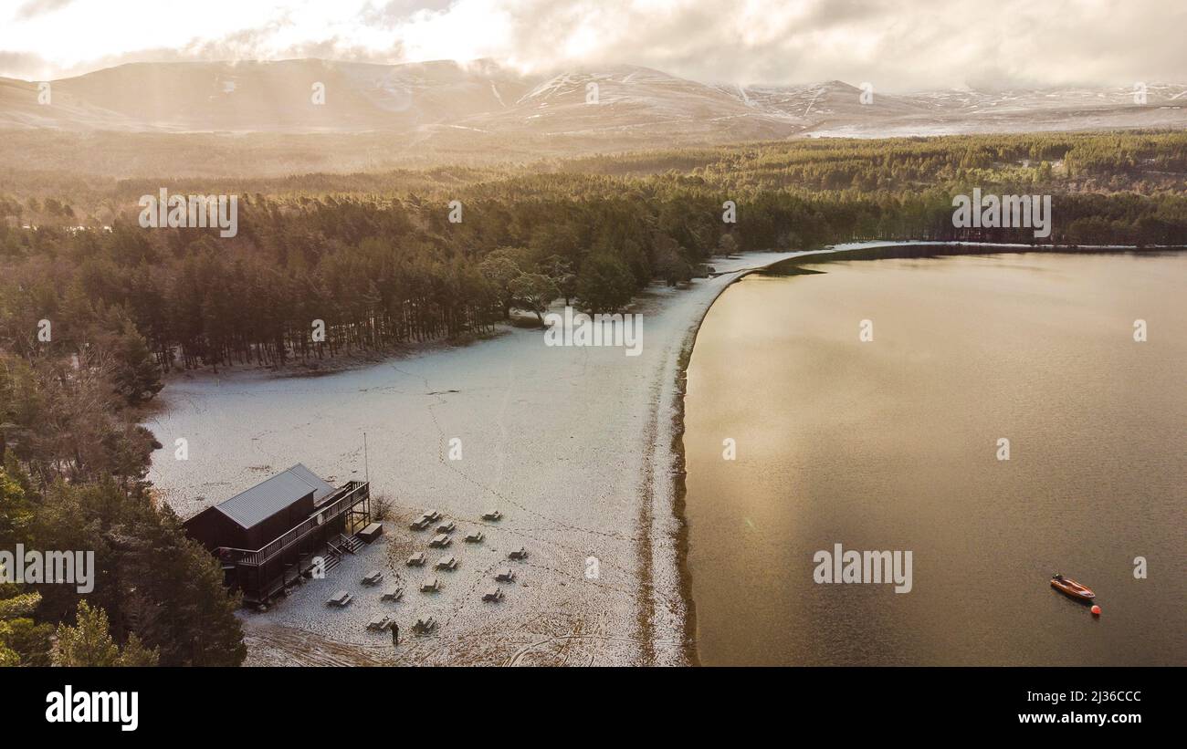 Loch Morlich beach in the Scottish highlands is snowfell, in aerial ...