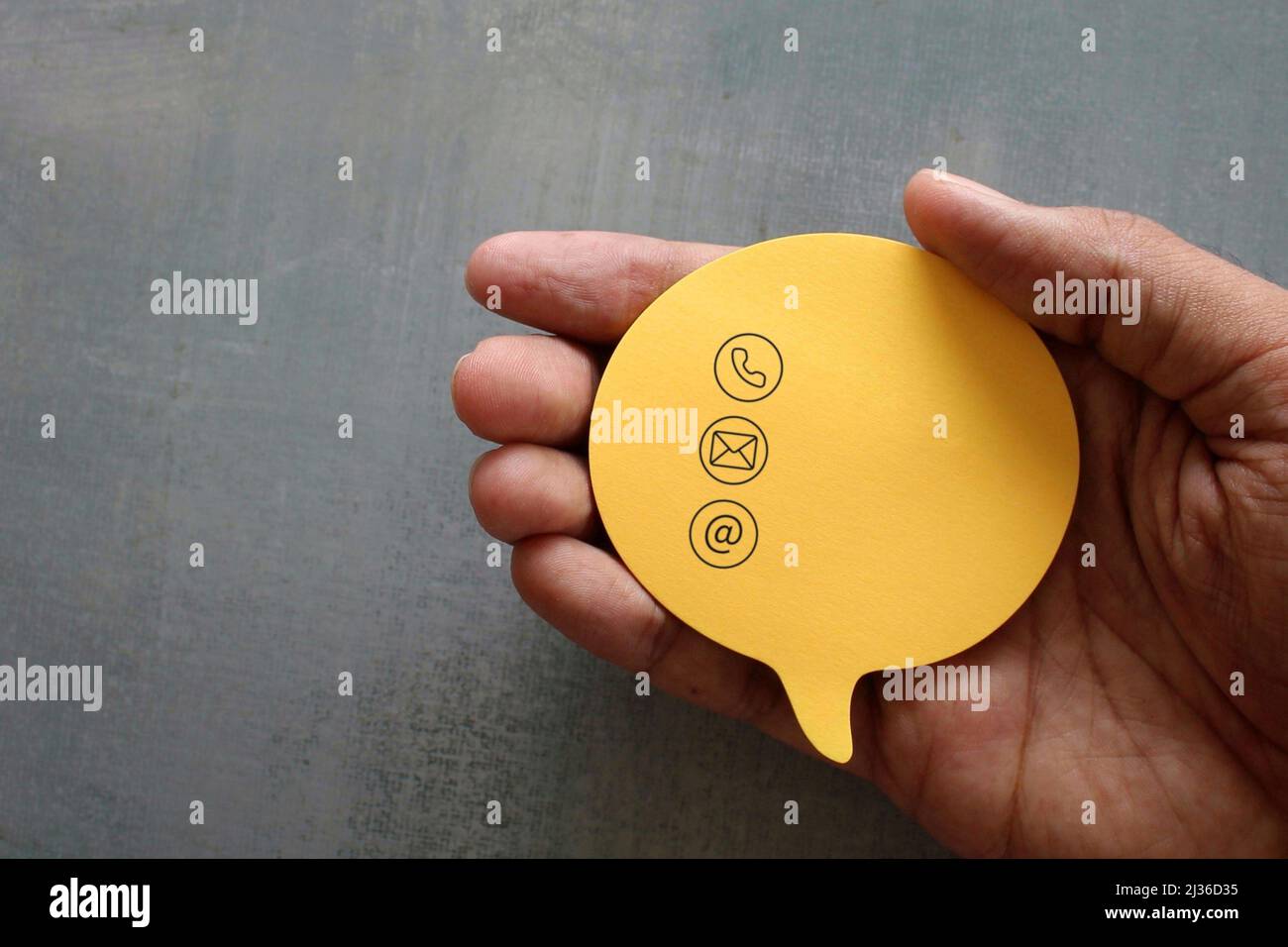 Hand holding speech bubble with phone, address and email icon. Business ...