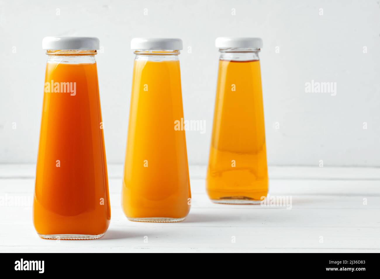 Glass bottles of different juices on white background Stock Photo - Alamy