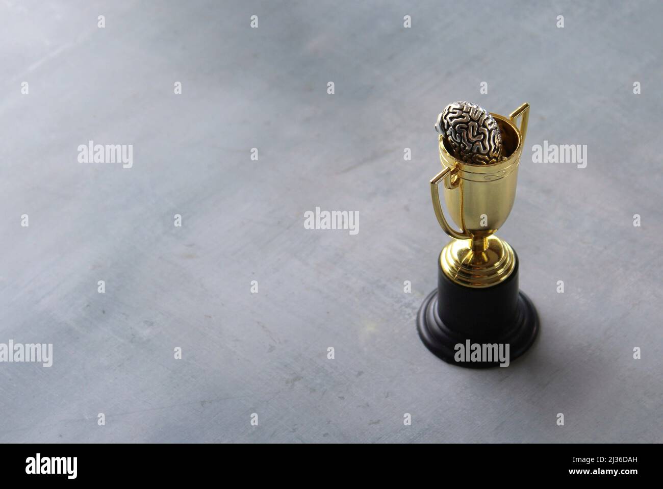 Brain inside gold cup trophy with copy space. Winning mentality and ...