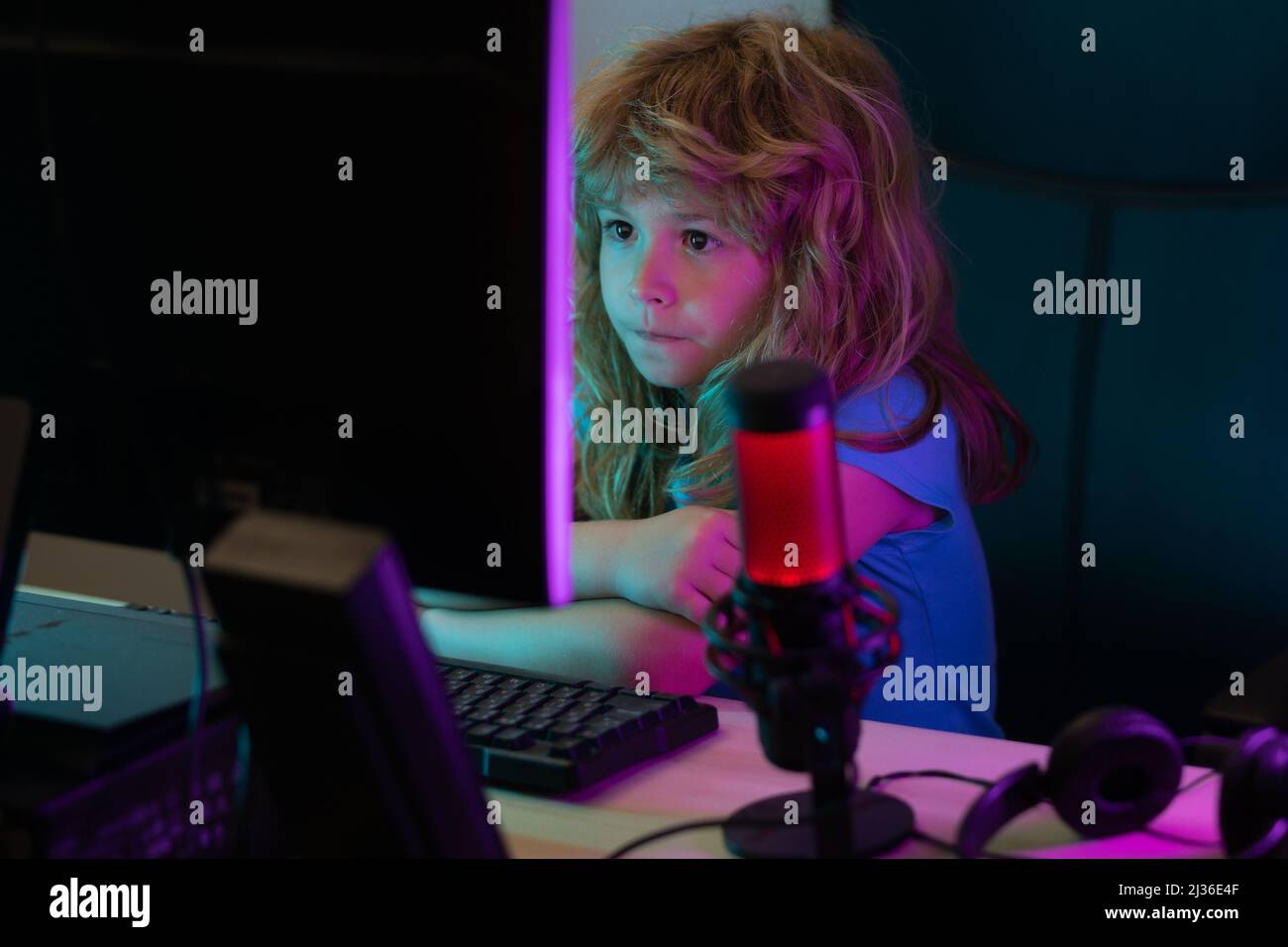 Little child gamer play computer game on desktop. Gaming stream and ...