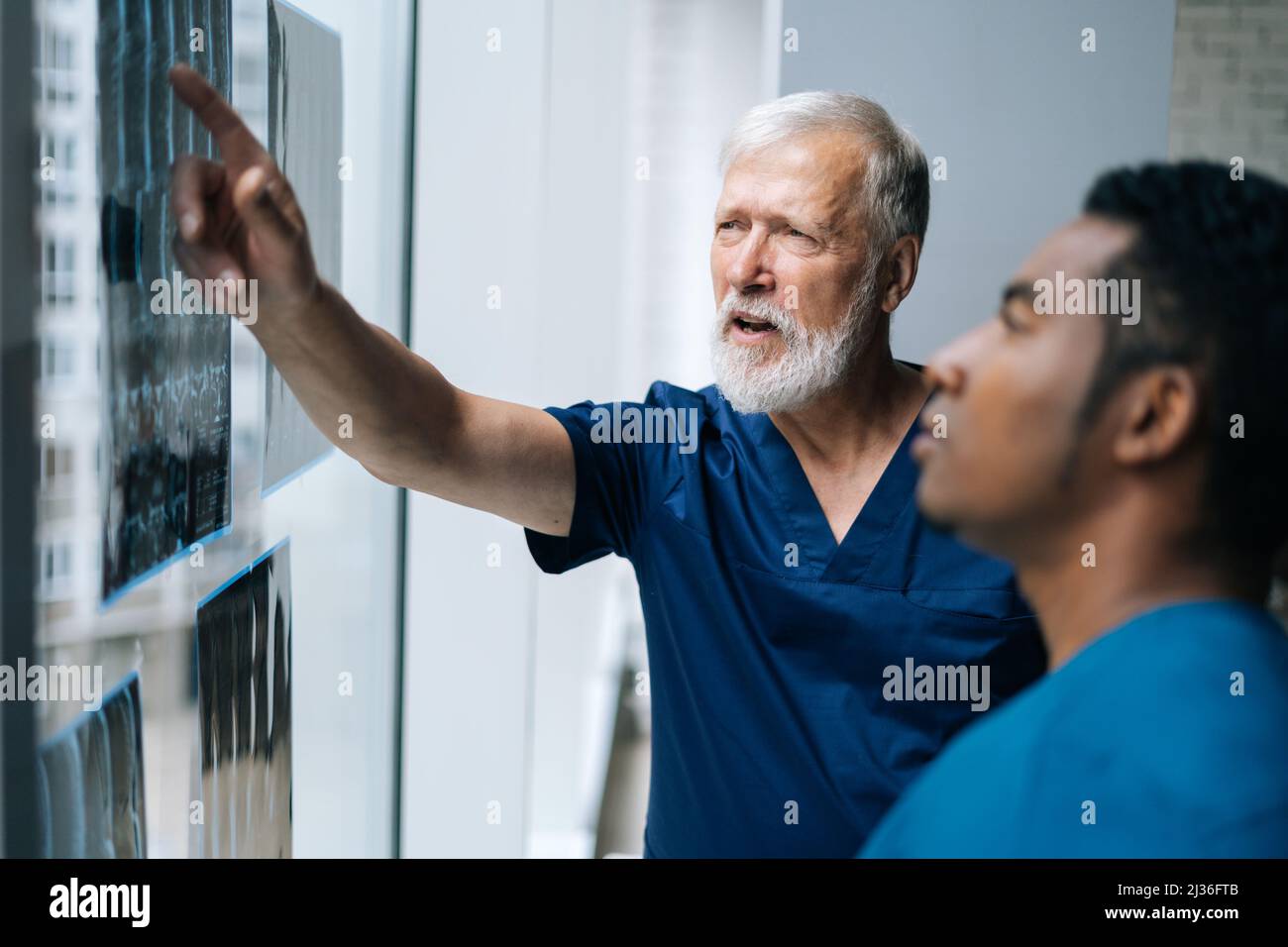 Close-up of team multi-ethnic doctors talking together history disease ...