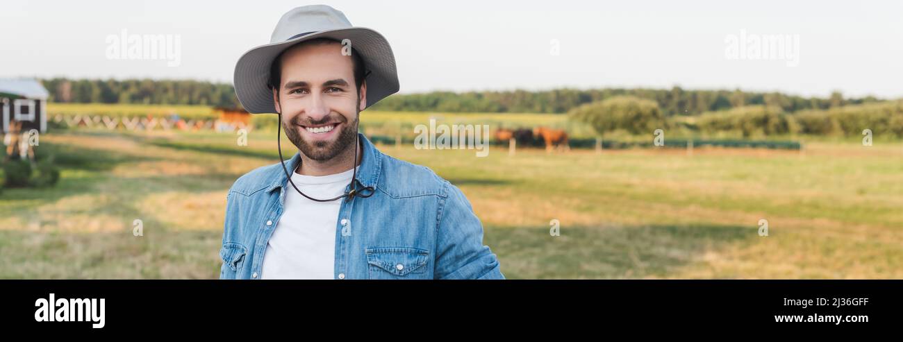 happy farmer smiling at camera in green field on farm, banner Stock ...