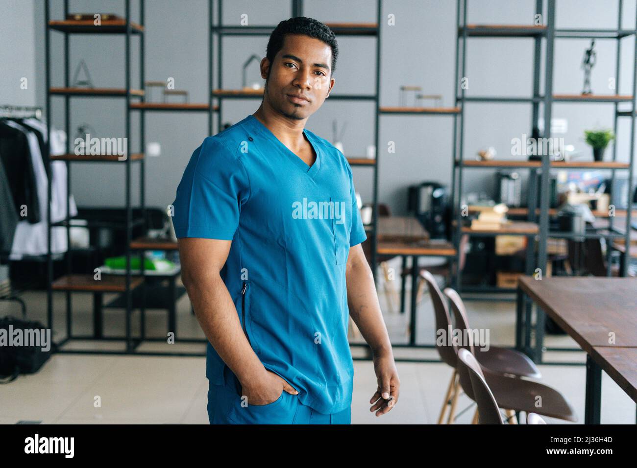 Portrait of confident African American man doctor wearing blue surgeon ...