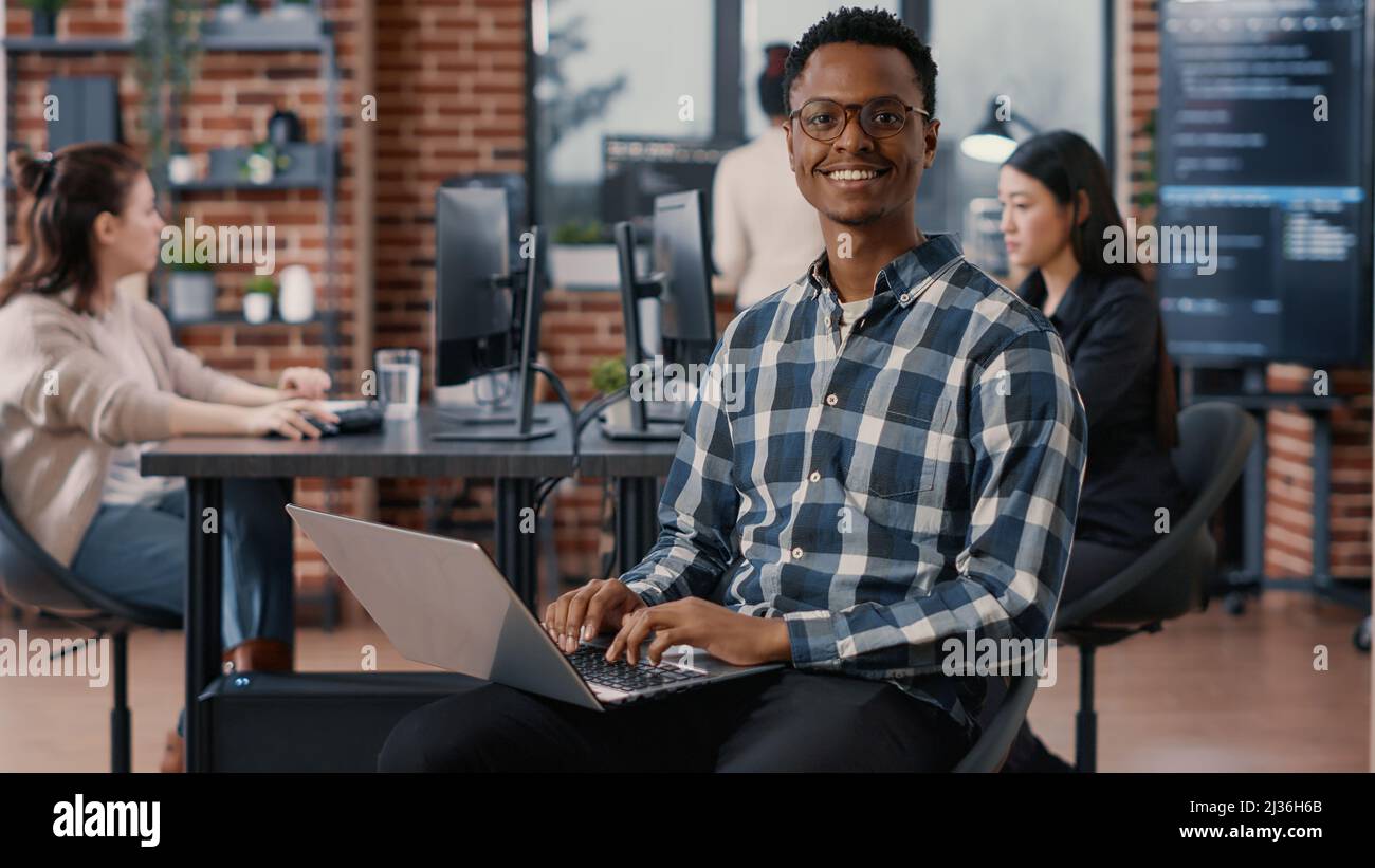 Portrait of artificial intelligence app developer sitting down typing ...