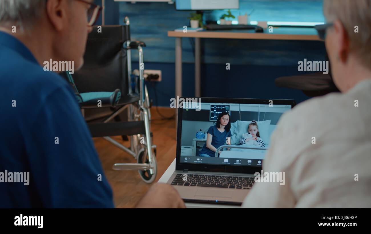 Grandparents talking to family in hospital on online conference, using ...