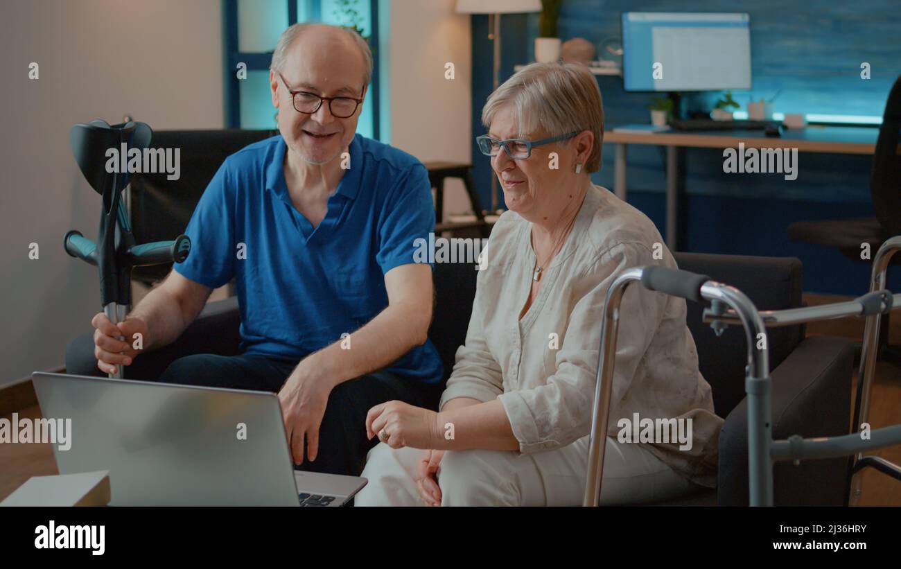 Couple with chronic disability giving high five after success on laptop ...