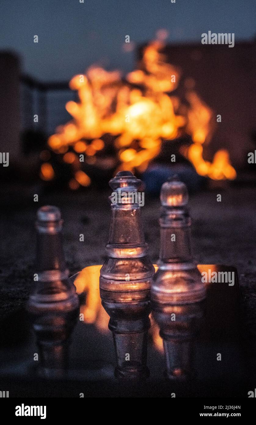 A vertical closeup of the transparent chess pieces against fire Stock ...