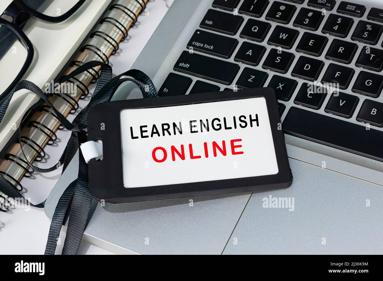 Learn english online text written on black name tag placed on a laptop ...