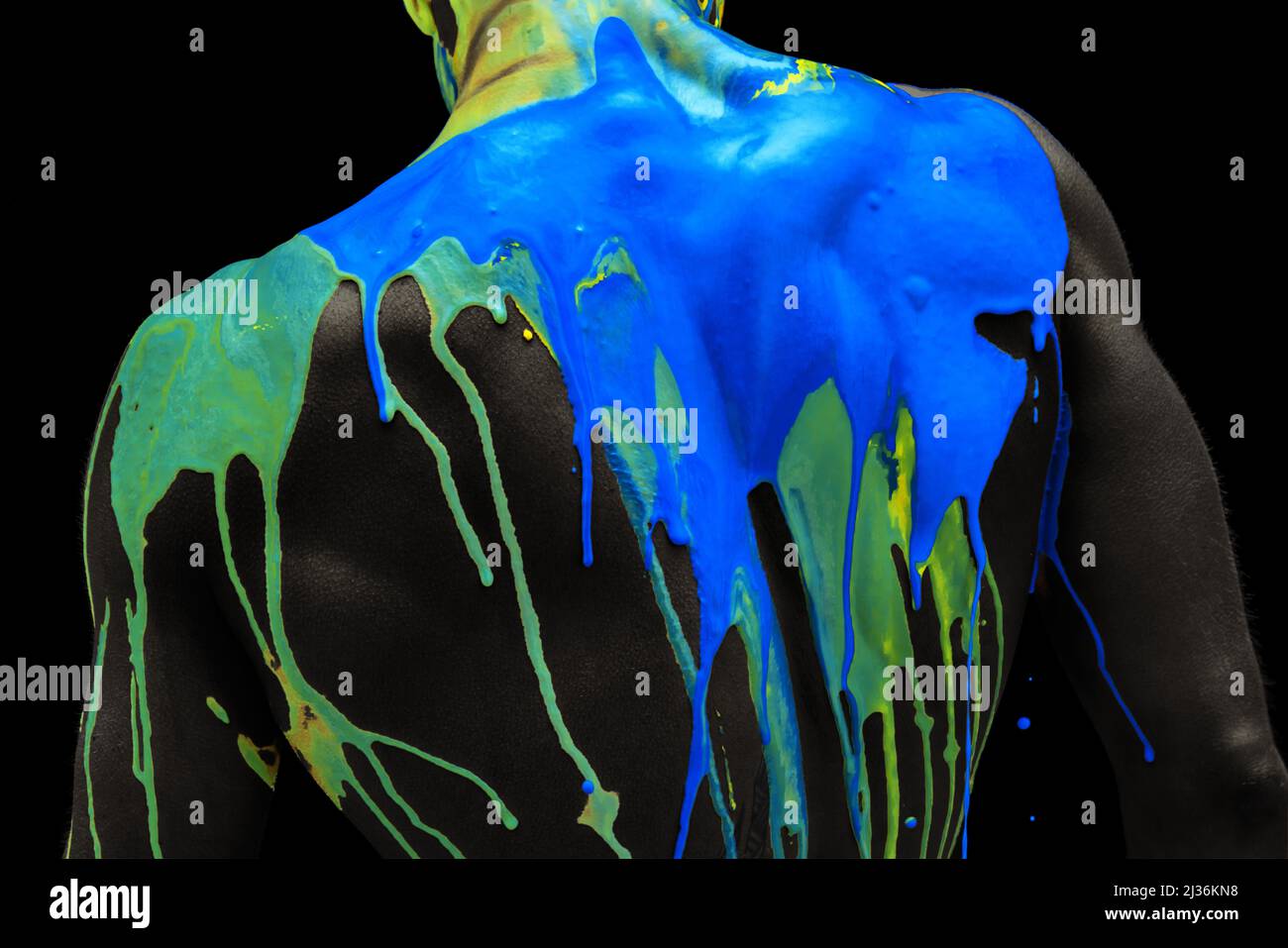 Rear view. Abstract art on human body. Multi-colored paints, dyes flow ...