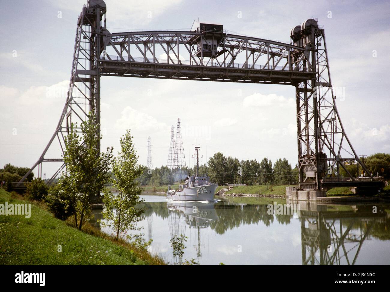 US naval boat passing under vertical-lift draw bridge, Welland canal ...
