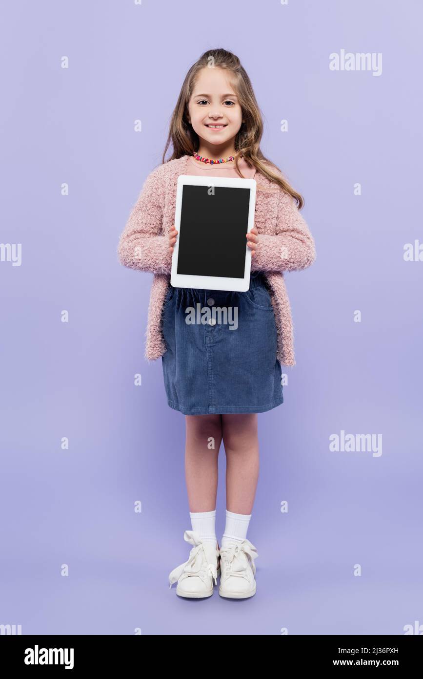 full length of cheerful girl holding digital tablet with blank screen ...