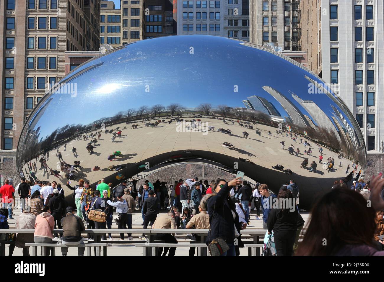 People standing around The Bean public art in downtown Millennium Park ...