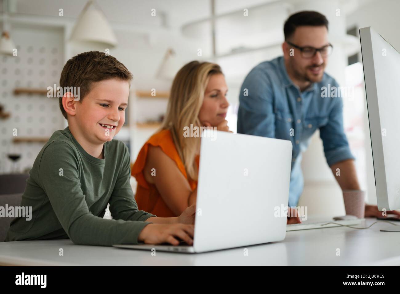 Happy family parent and child at home working on the computer. Business ...