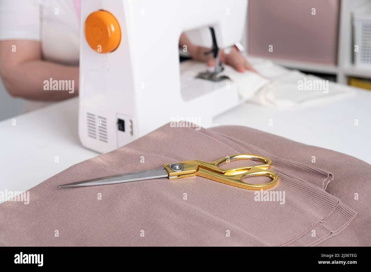 Real middle aged woman tailor sewing clothes using a sewing machine at ...