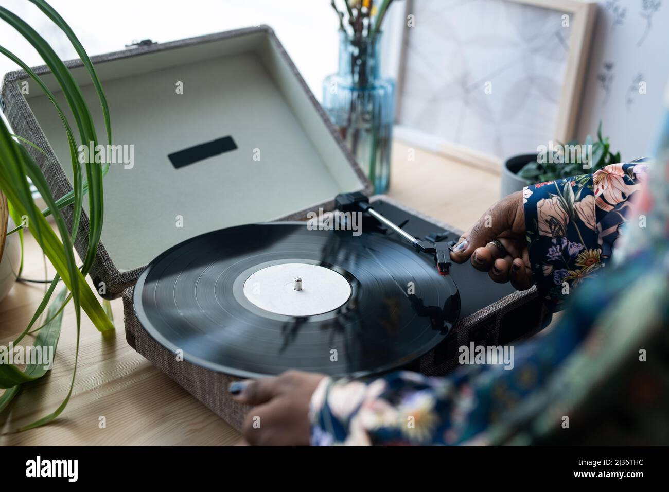 Unrecognizable young man standing in front of window turning on music ...