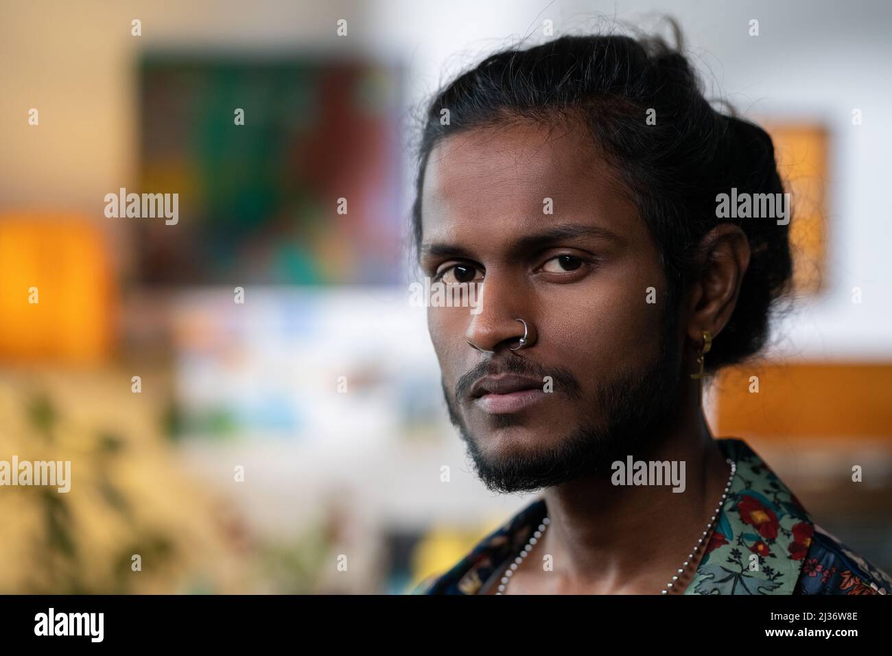 Close-up portrait of handsome non-binary young man of Indian ethnicity ...