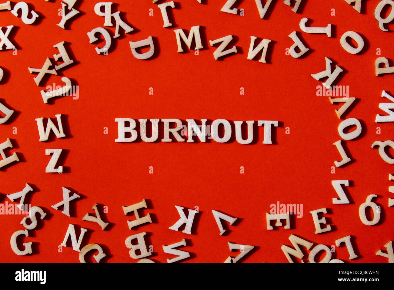 Word BURNOUT made out of wooden letters on bright red background ...