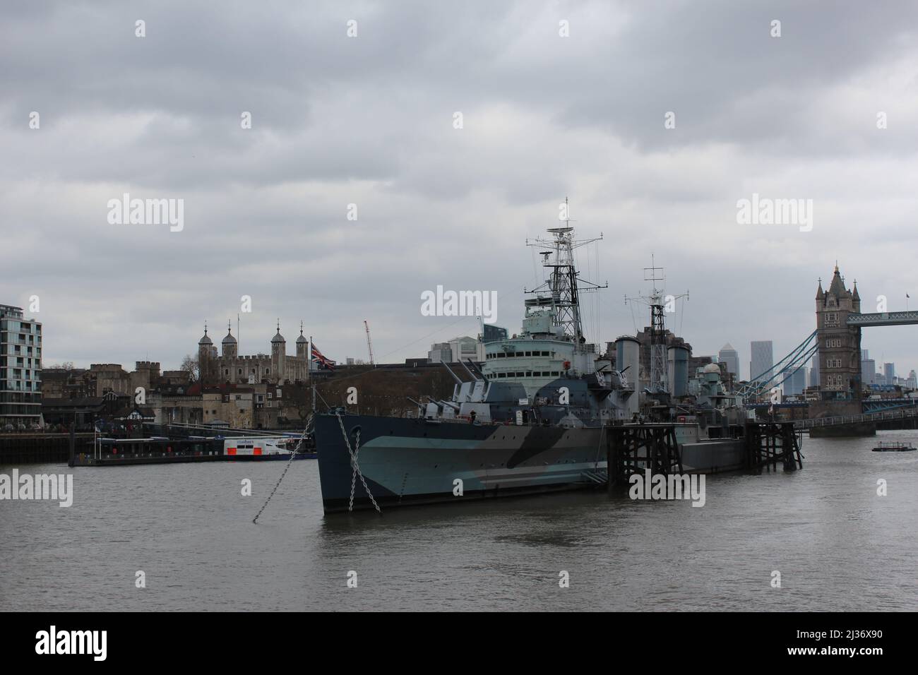 HMS Belfast on the River Thames and the Tower of London Building in the ...