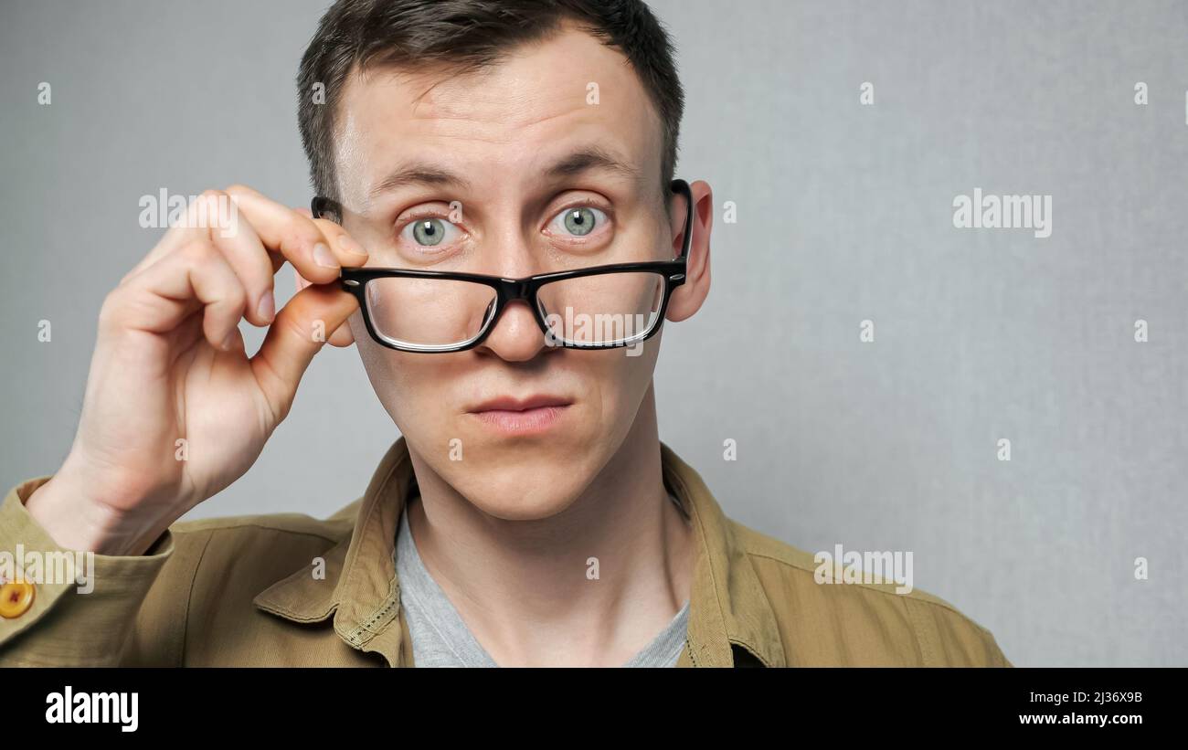 Man with bad eyesight removes glasses getting surprised Stock Photo - Alamy