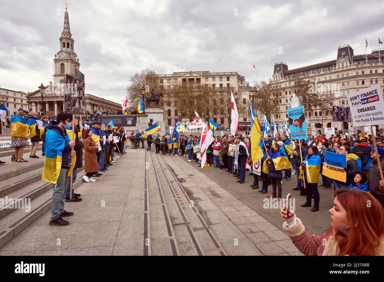Line of demonstrators with signs facing crowd on one side with crowd ...
