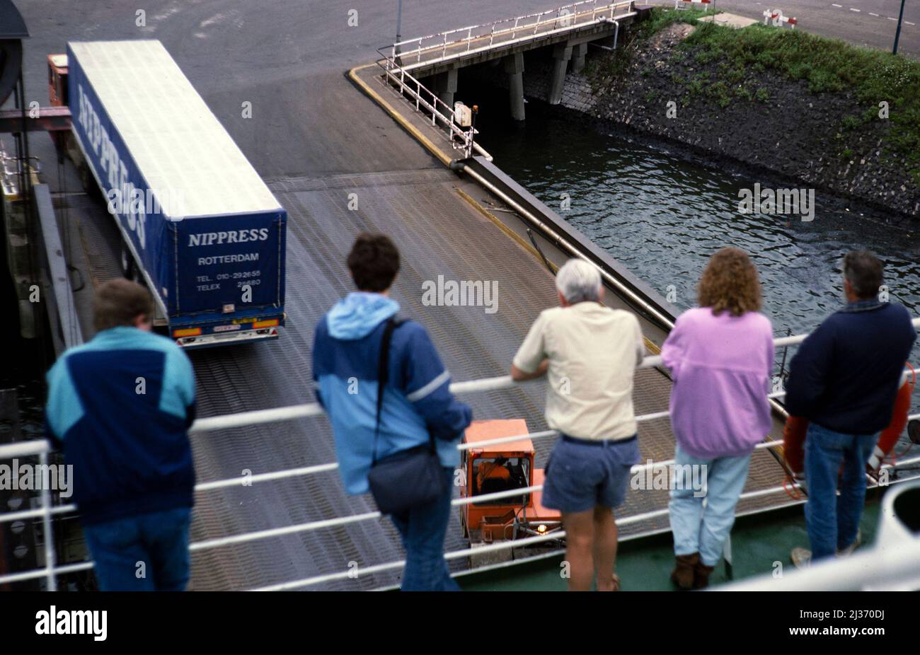 Passengers watch loading of freight onto ferry ship, Norsun, North Sea ...