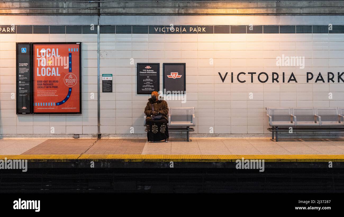 A Muslim woman sits on a bench waiting for a TTC subway train in the ...
