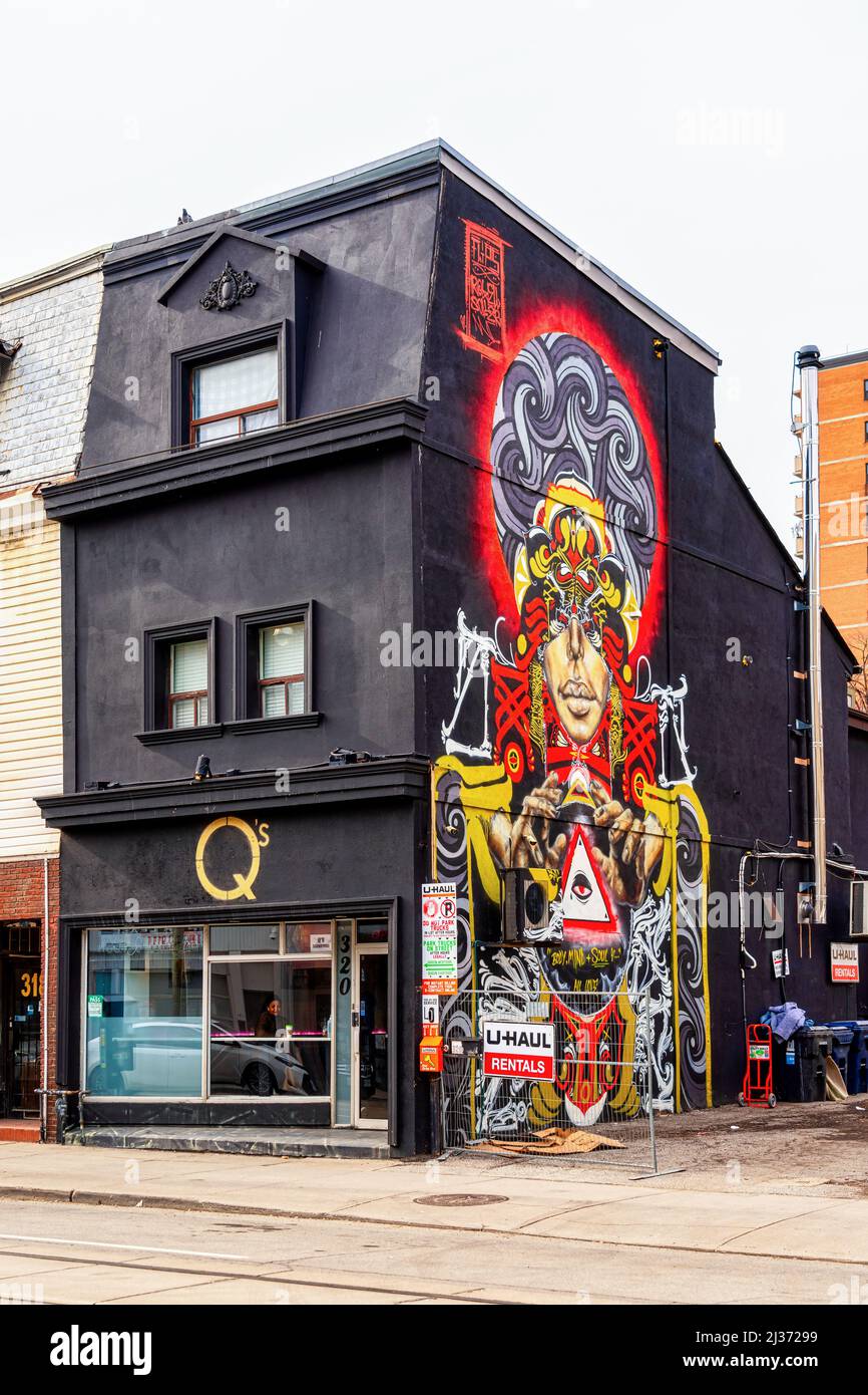 Small business facade with a urban art graffiti in the lateral wall ...