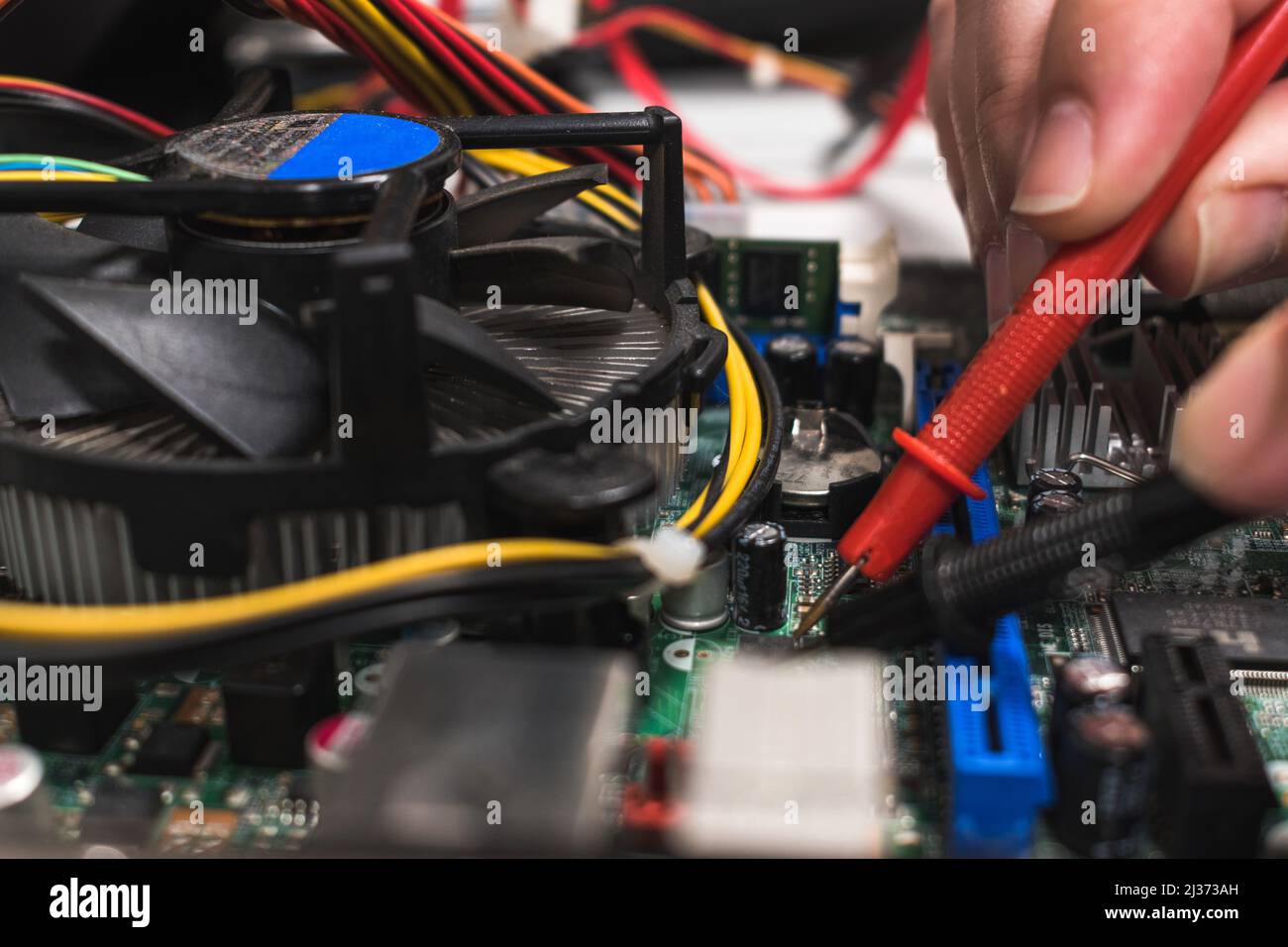 IT technician mesuring the resistance on a computer motherboard Stock ...