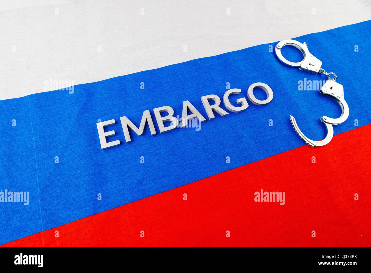 the word embargo laid with silver metal letters on russian tricolor ...
