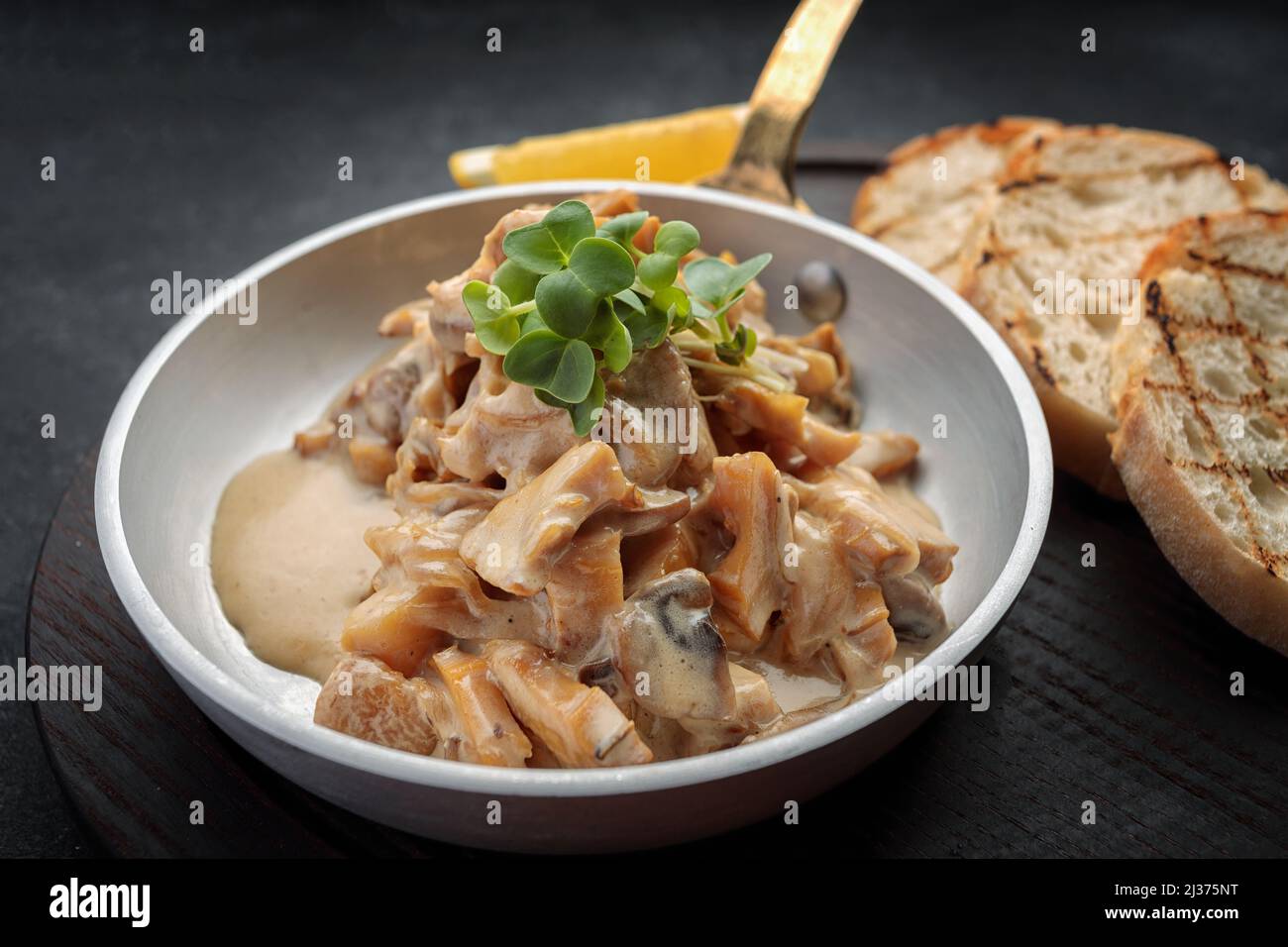 Rapani in a creamy sauce with lemon and toast, in a frying pan, on a ...