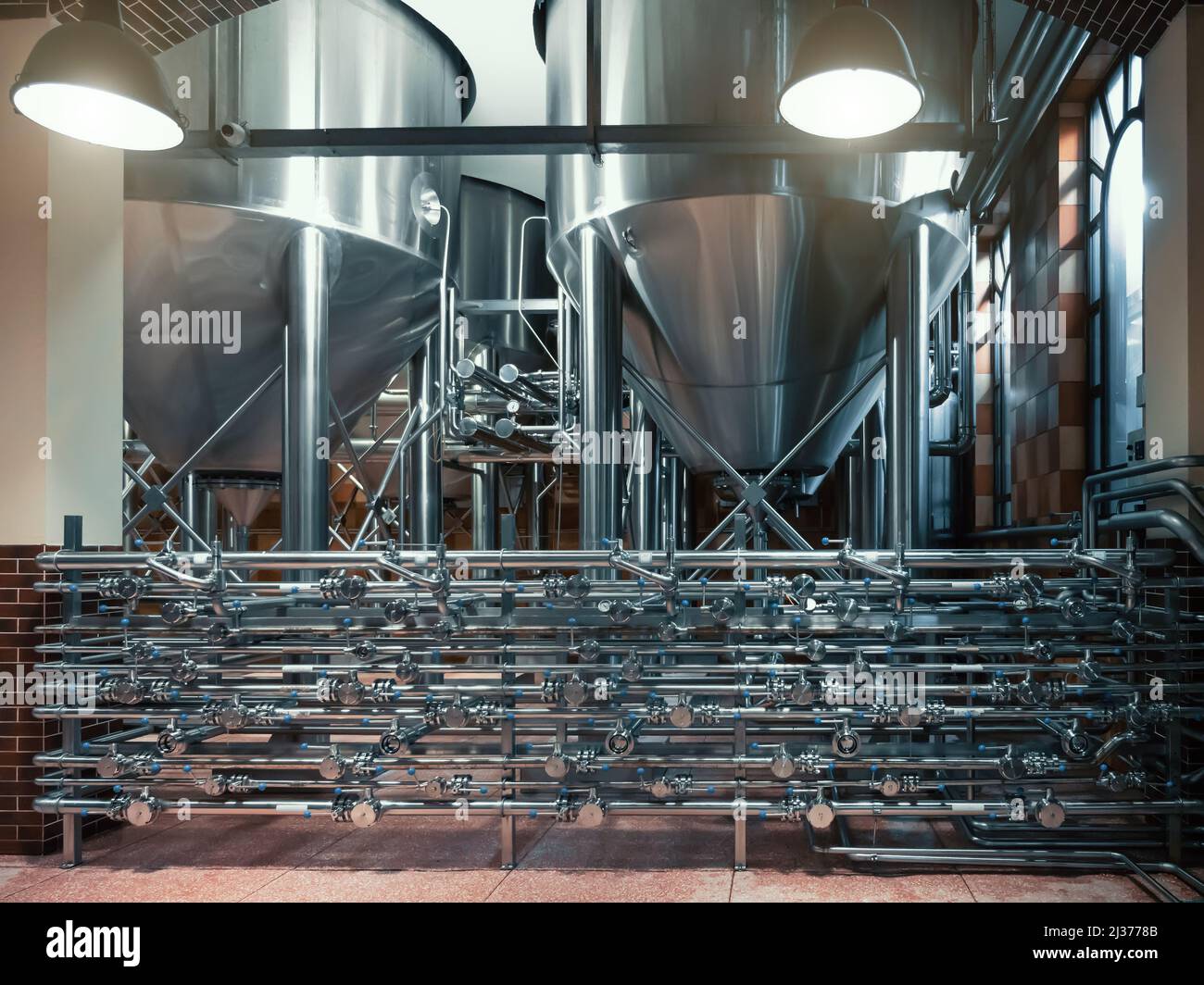 Beer tanks with many steel pipes in craft brewery Stock Photo - Alamy