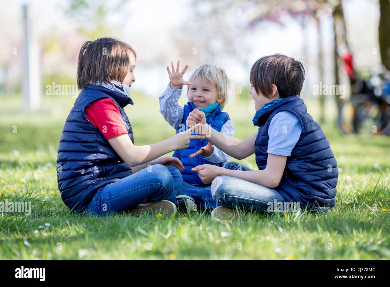 Three children, boy brothers, playing rock scissors paper game in ...