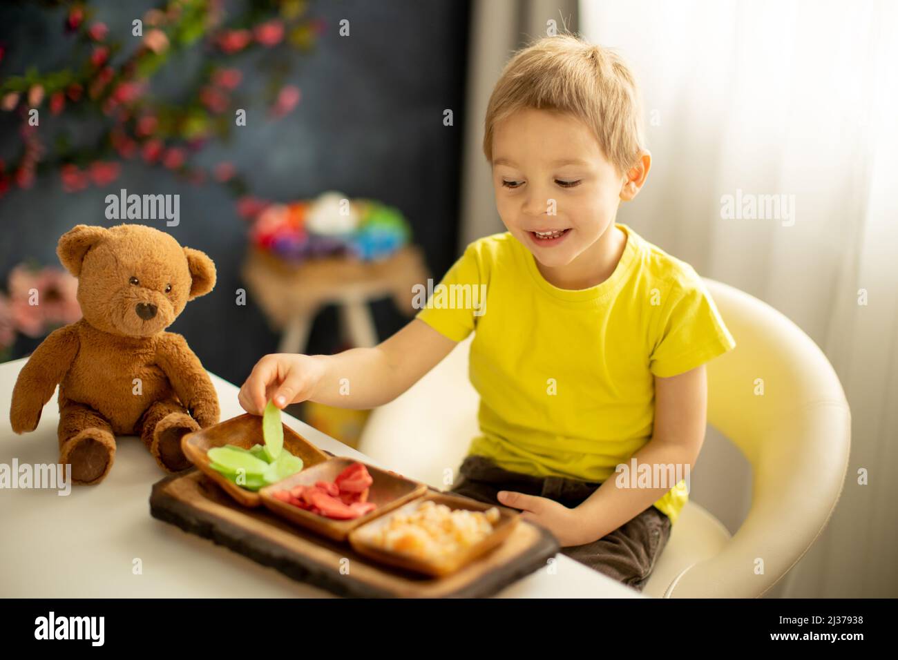 Cute little preschool child, boy, eating dried fruits at home ...