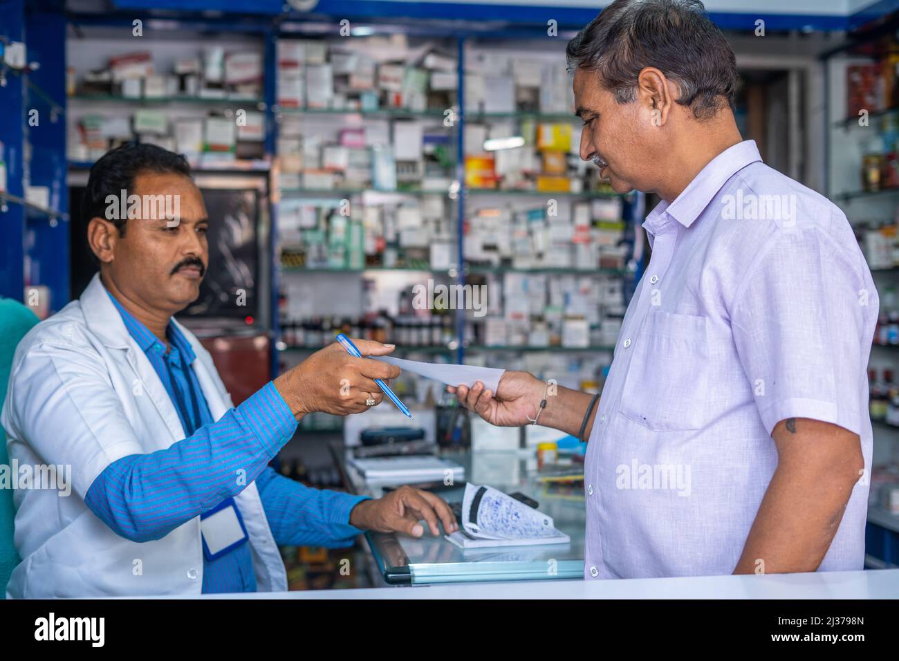 Customer asking medicine to pharmacist by showing doctor proscription ...