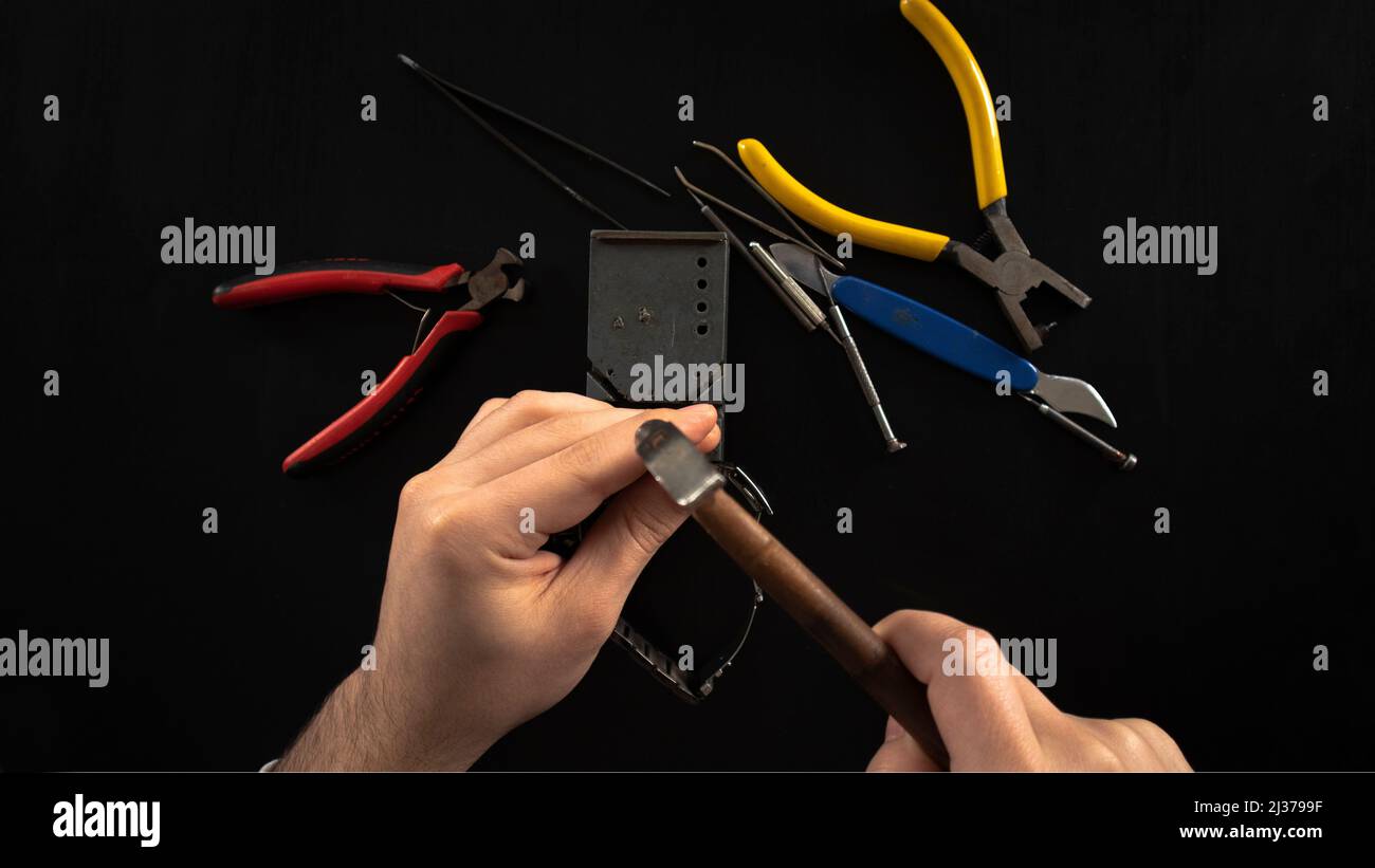 Repairing watch with tools, isolated on black background, repare metal ...