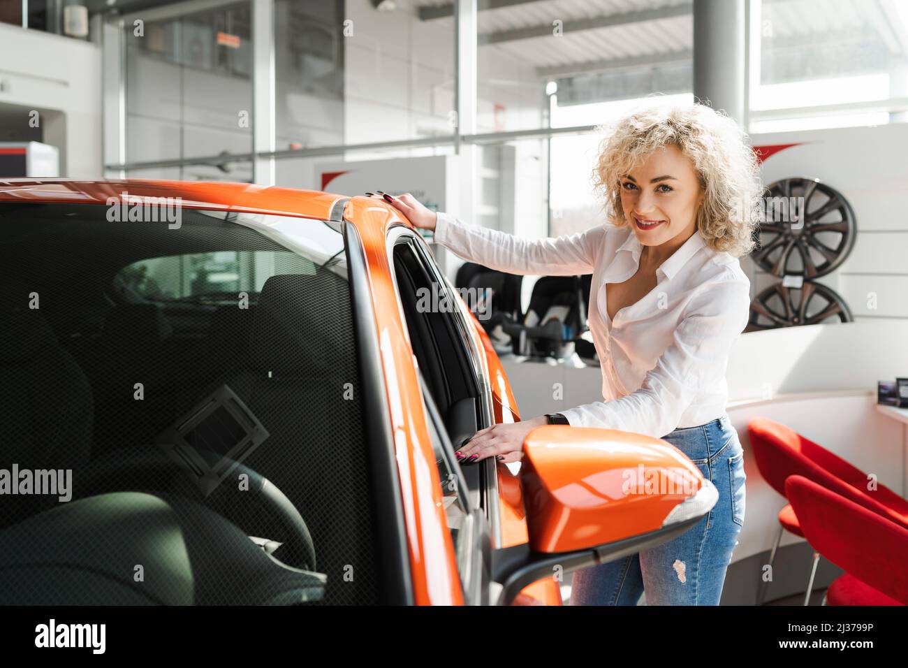 Blonde woman in dealership buys a new car Stock Photo - Alamy