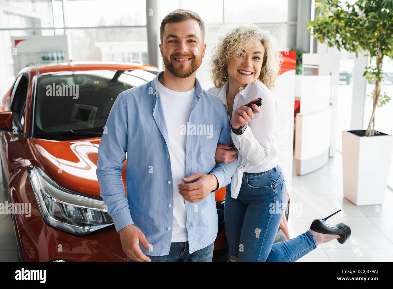 Happy couple and their new car in dealership Stock Photo - Alamy