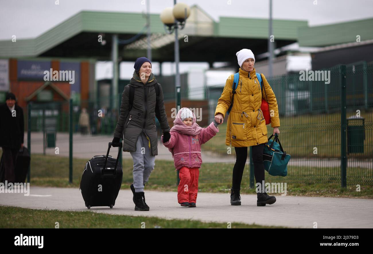 Ukrainian refugees walk after crossing the Ukraine-Poland border, amid ...