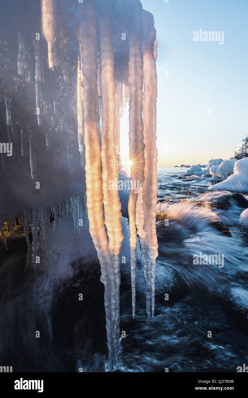 Sun rays shining through the set of big icicles Stock Photo - Alamy