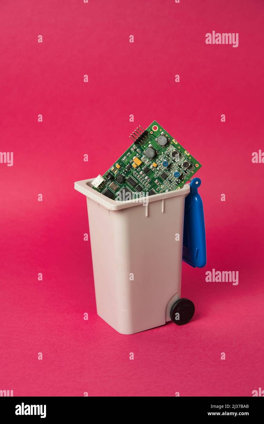 garbage can with an electronic board with digital components on a pink ...