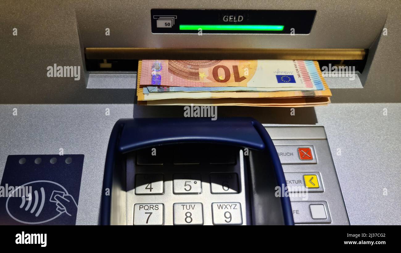 A closeup of aGerman ATM dispensing euro bills at a VR Bank branch ...