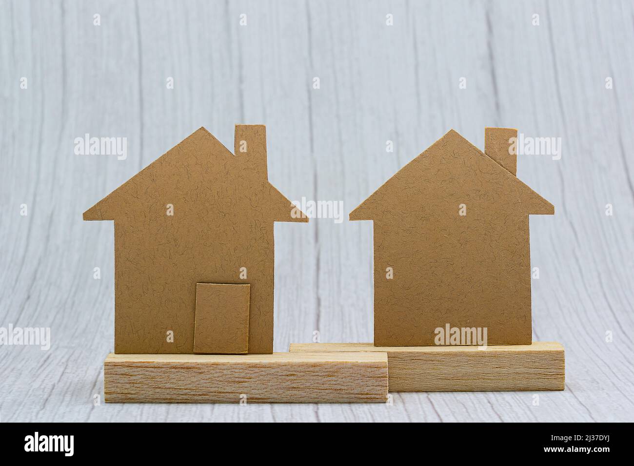 House brown paper model on white wooden background. Property investment ...