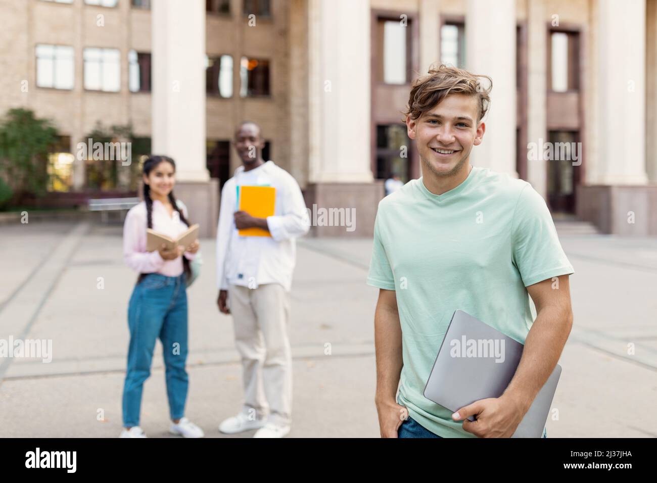 Happy multiracial university students posing outdoors near university ...