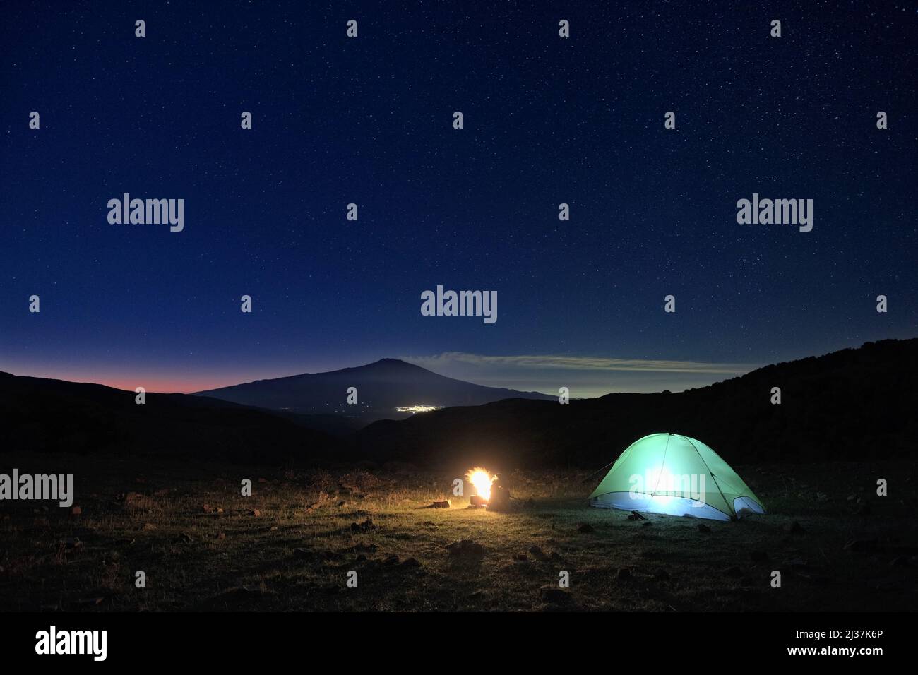 lighting tent, campfire and Etna Volcano at dawn from Nebrodi Park ...
