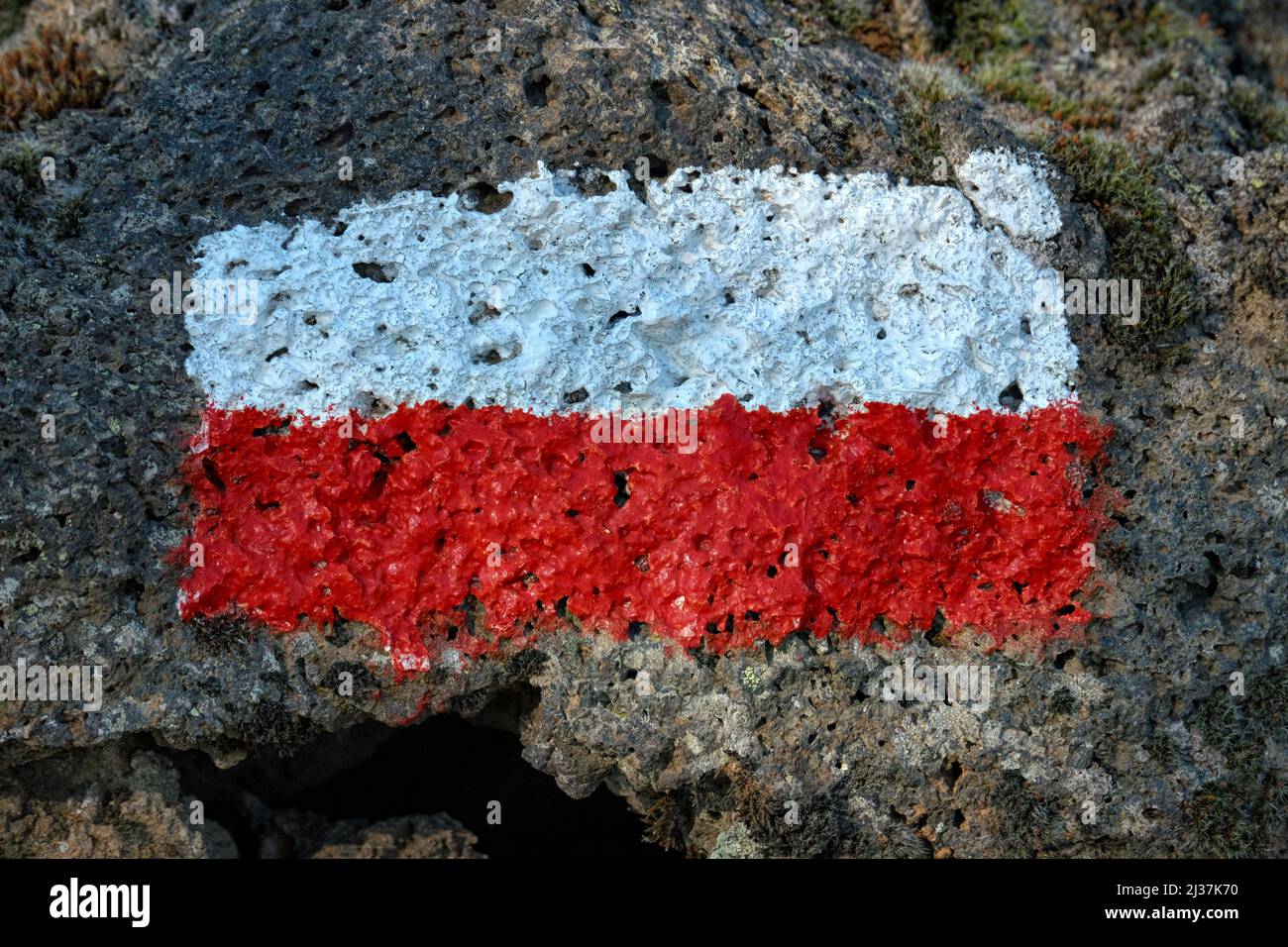 red and white horizontal stripes trail mark on volcanic rock in Etna ...